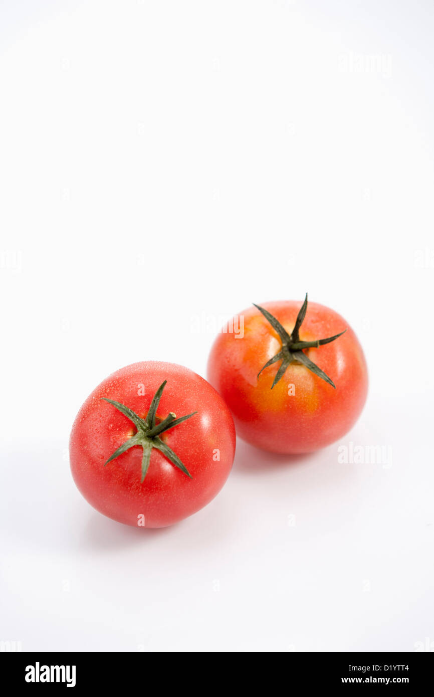 two tomatoes in white background Stock Photo - Alamy