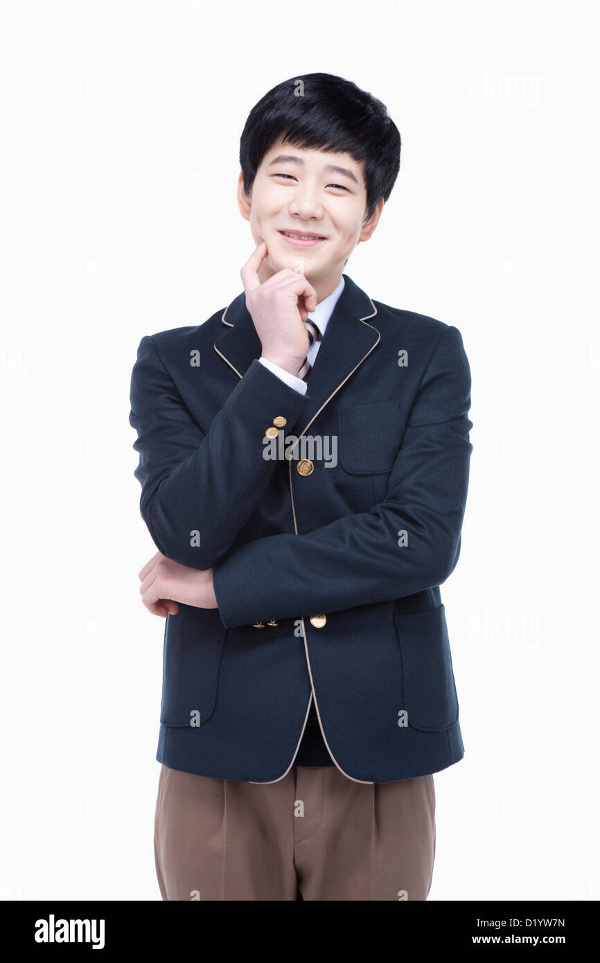 a male student wearing school uniform smiling with thinking position ...