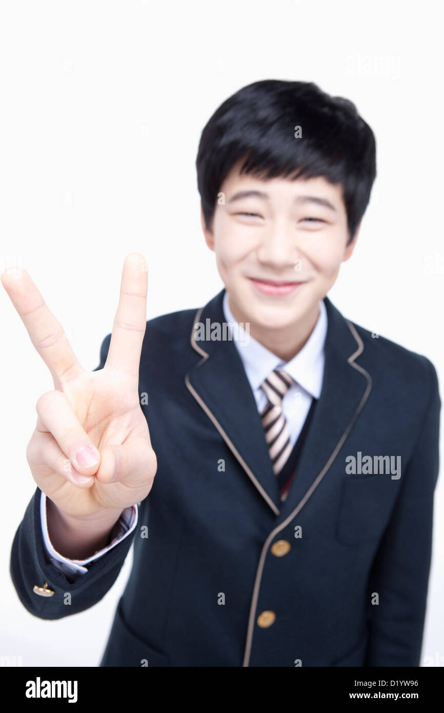 a male student wearing school uniform showing v sign Stock Photo - Alamy