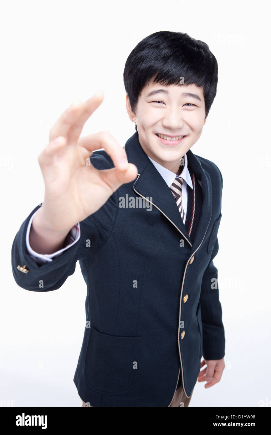 a male student wearing school uniform showing ok sign Stock Photo - Alamy