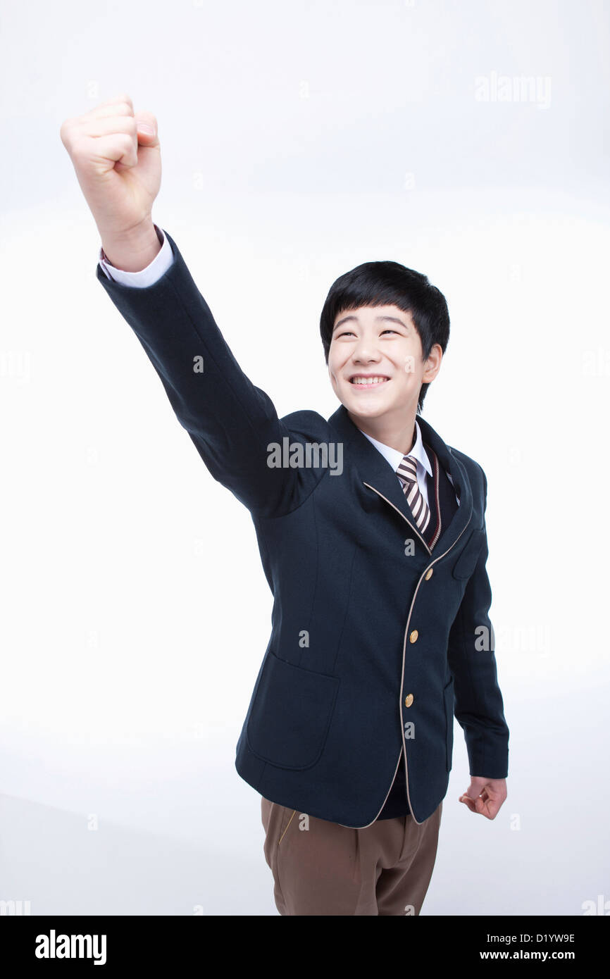 a male student wearing school uniform standing with a fist up Stock ...