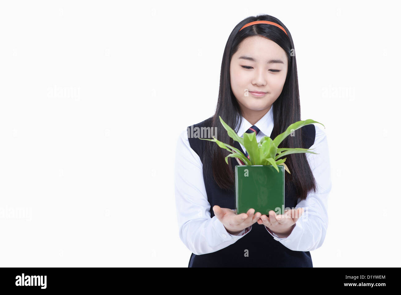 a female student wearing school uniform holding a plant pot Stock Photo ...