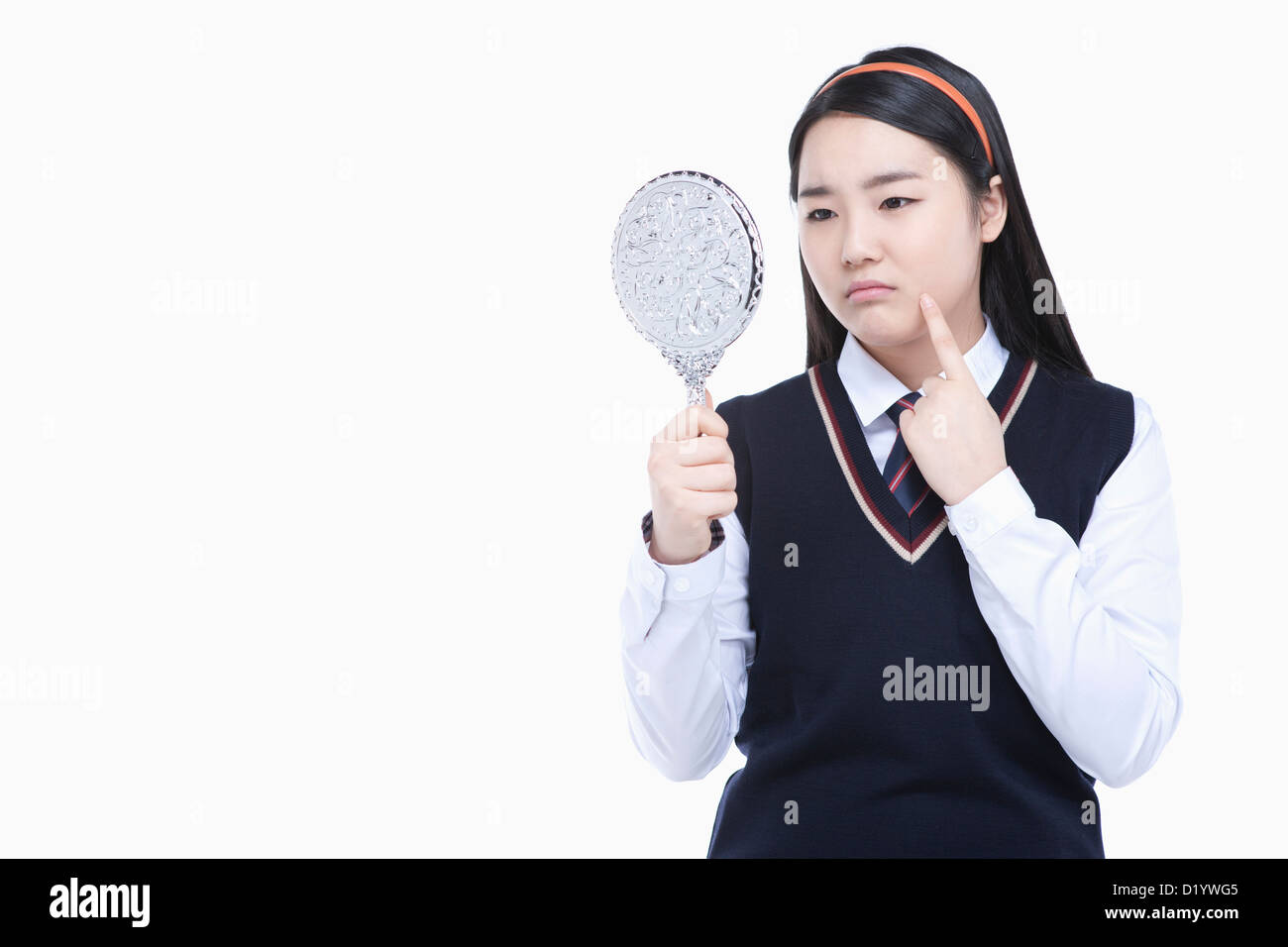 a female student wearing school uniform looking at herself through a ...