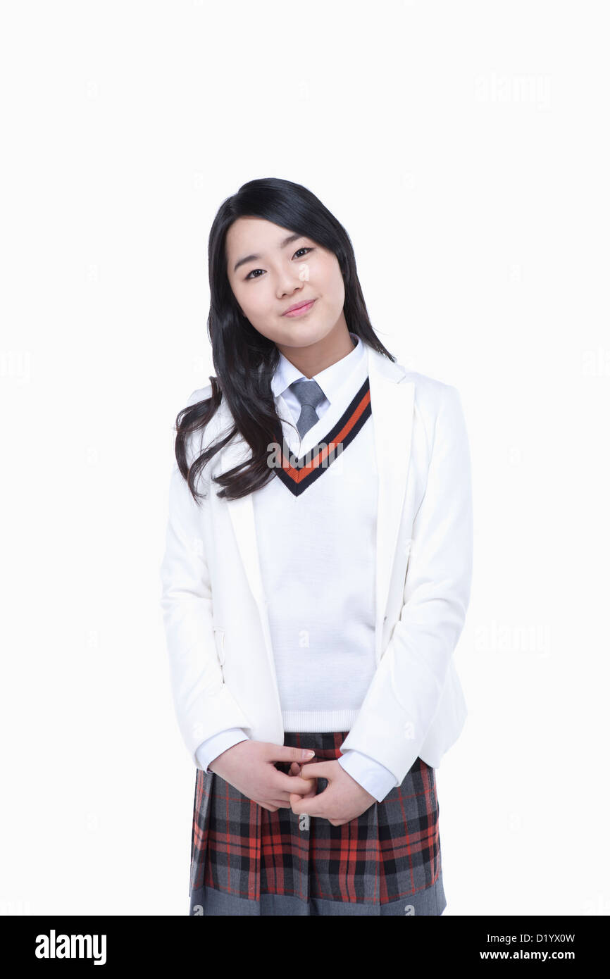 a female student in school uniform wearing a white jacket standing with ...