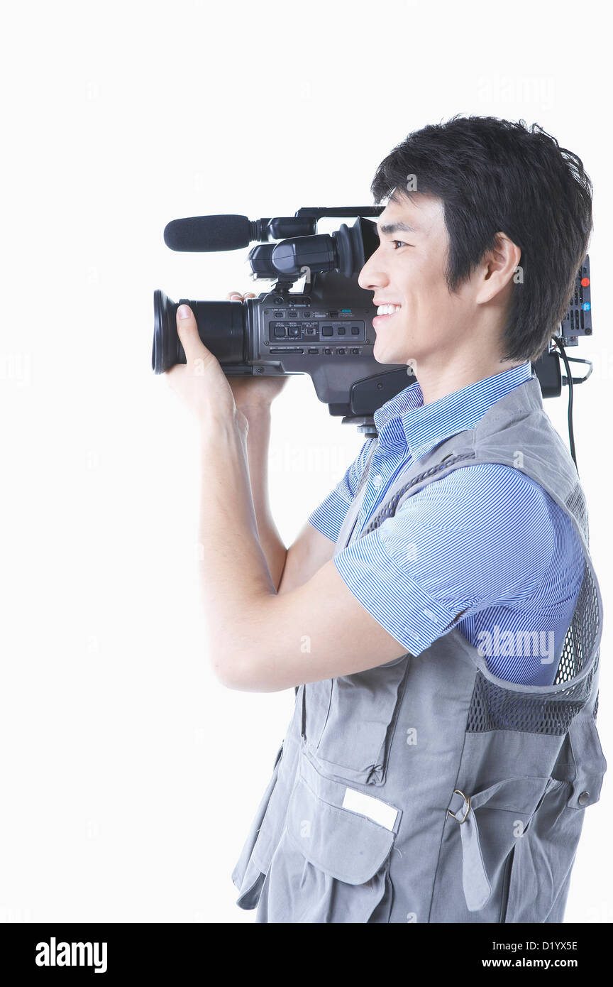 a cameraman standing in sideway in white background Stock Photo - Alamy