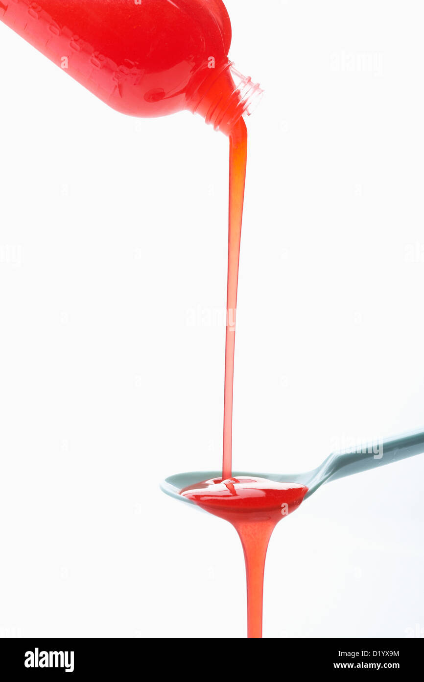 pouring red syrup in a spoon Stock Photo - Alamy