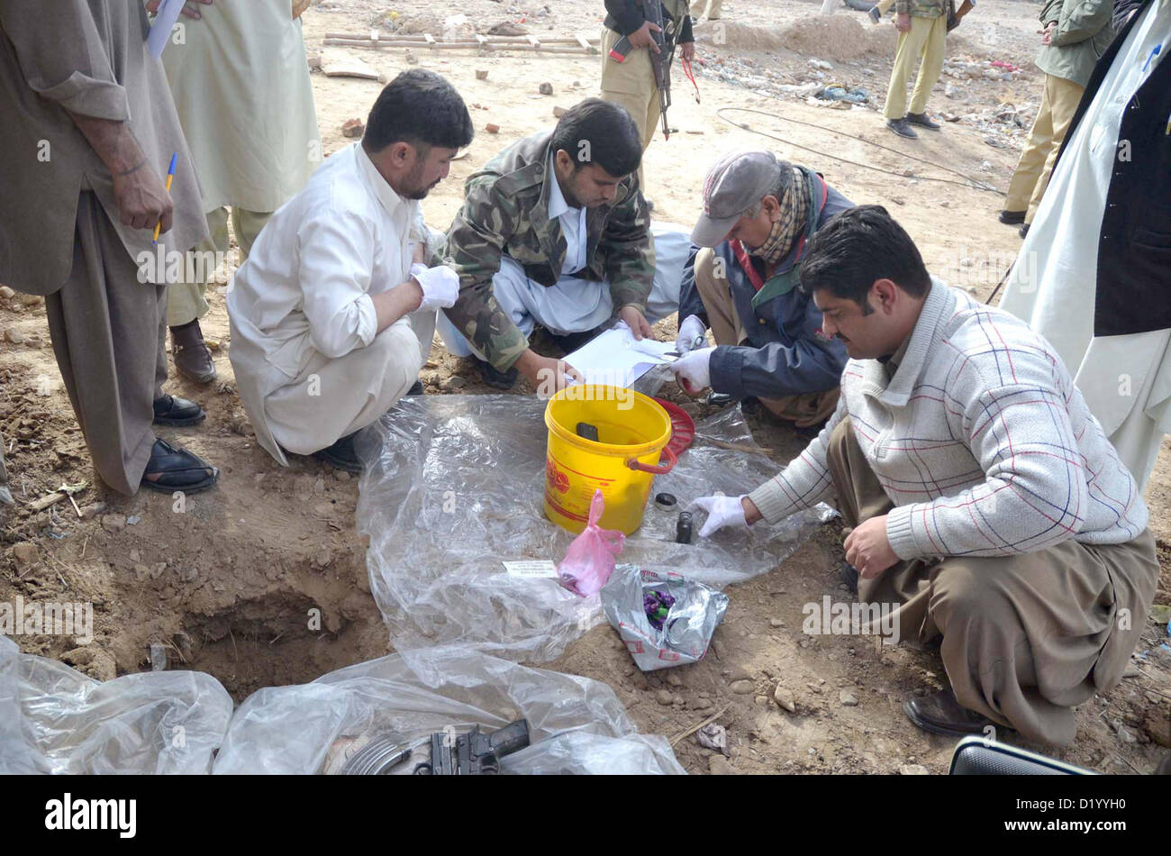 Police officials check seized weapons that recovered during a raid on ...