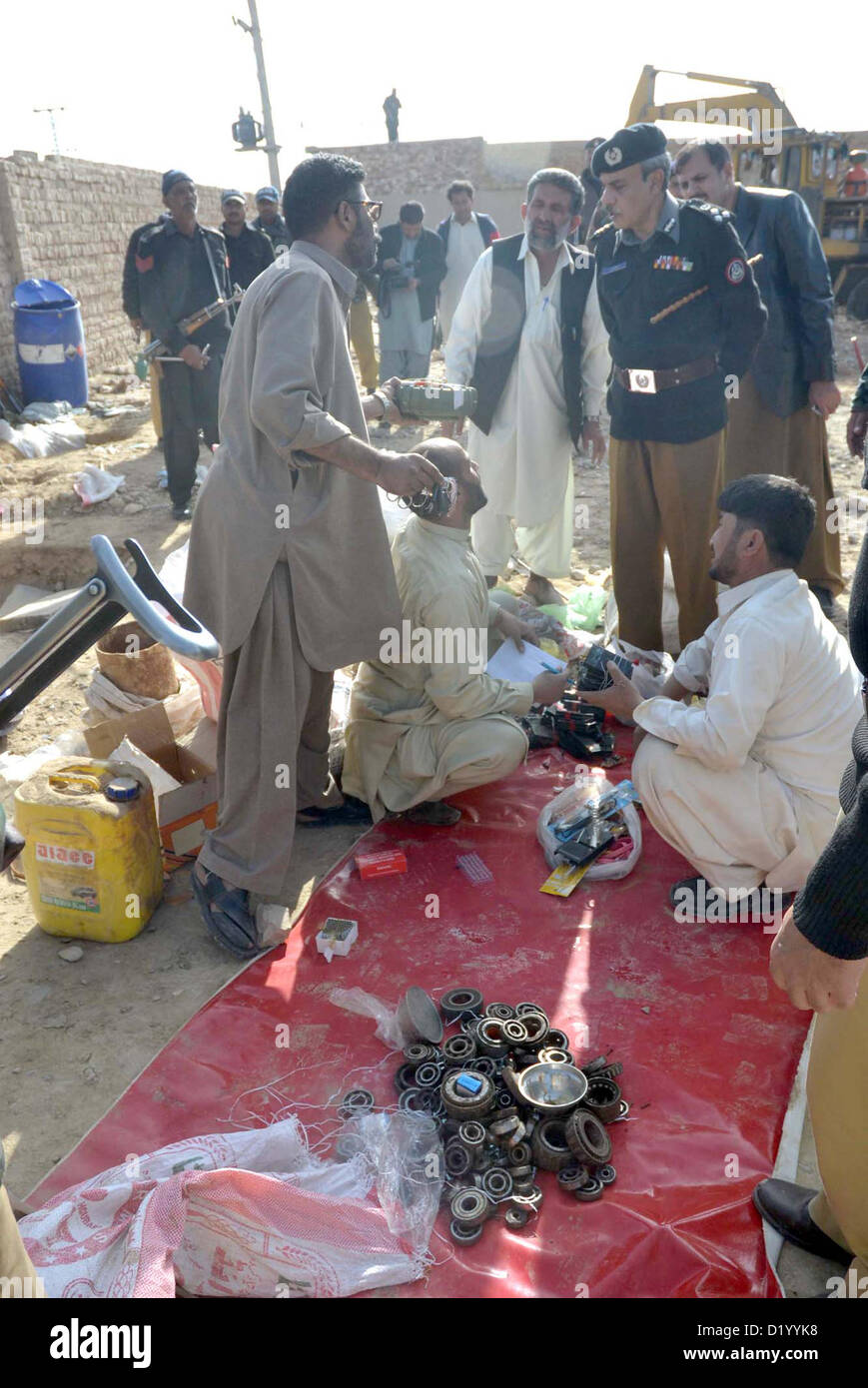 Police officials check seized weapons that recovered during a raid on ...