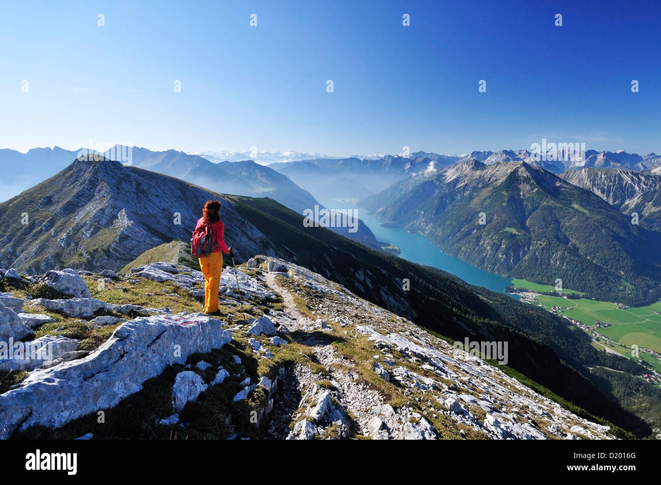 Woman walking at Unnutz with view to lake Achensee, Rofan mountain ...