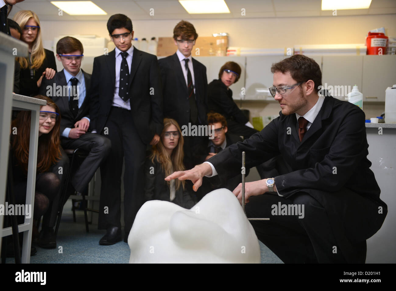A teacher demonstrates a chemistry experiment during a science lesson ...