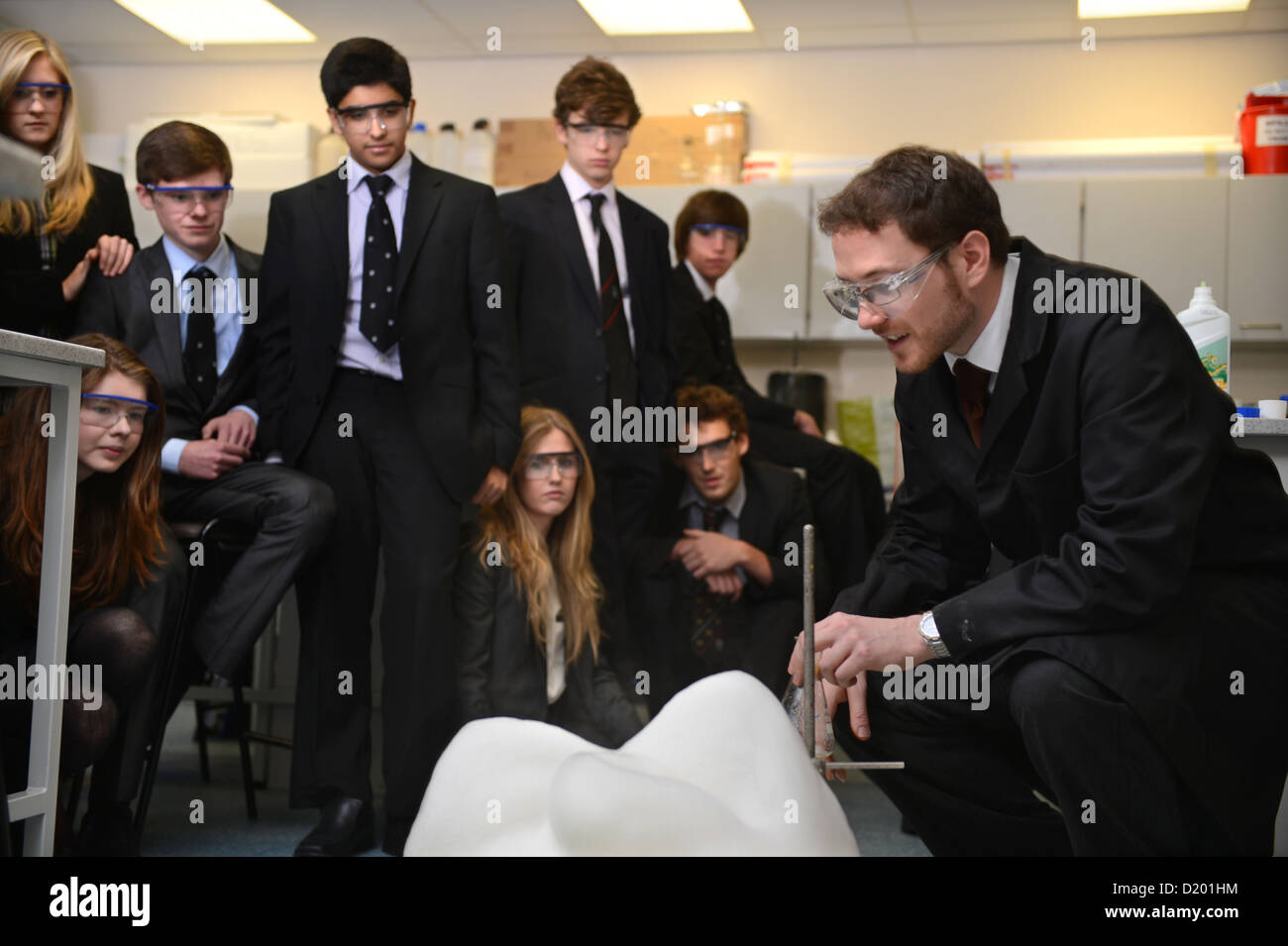 A teacher demonstrates a chemistry experiment during a science lesson ...