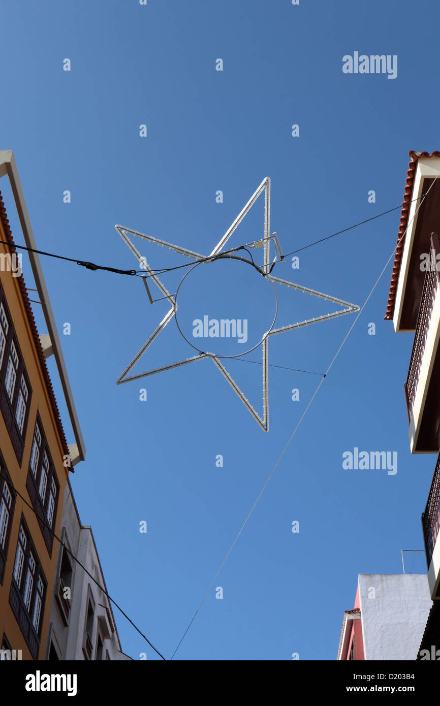 Star, Christmas decoration against blue sky, hanging above street ...