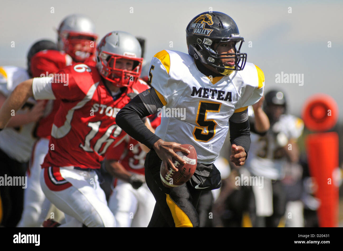 Football Quarterback rolls out from the pocket avoiding defensive rush ...