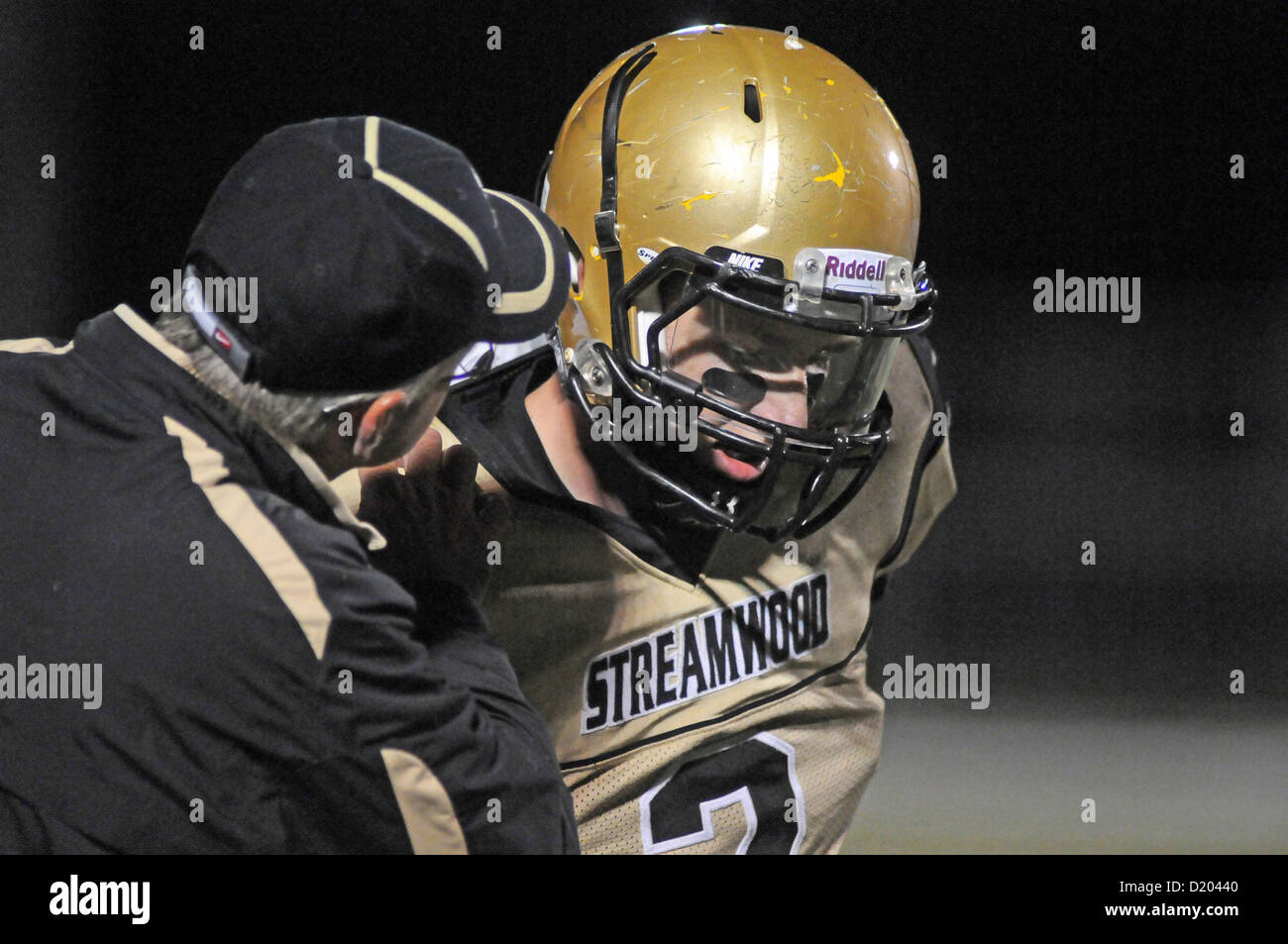 Football coach provides play instructions to his quarterback prior to a ...
