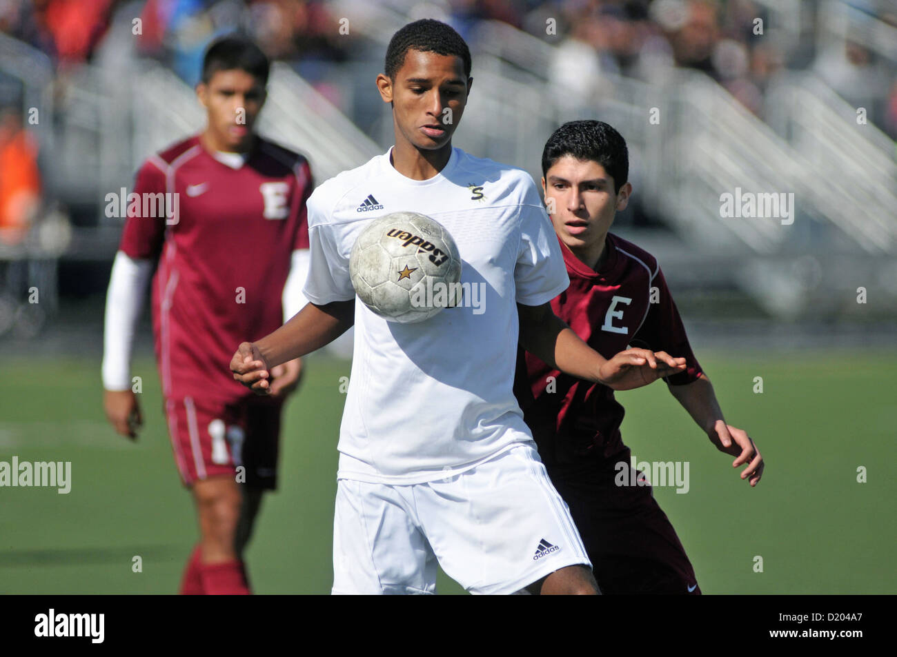 Soccer player plays the ball off his chest while shielding the effort ...