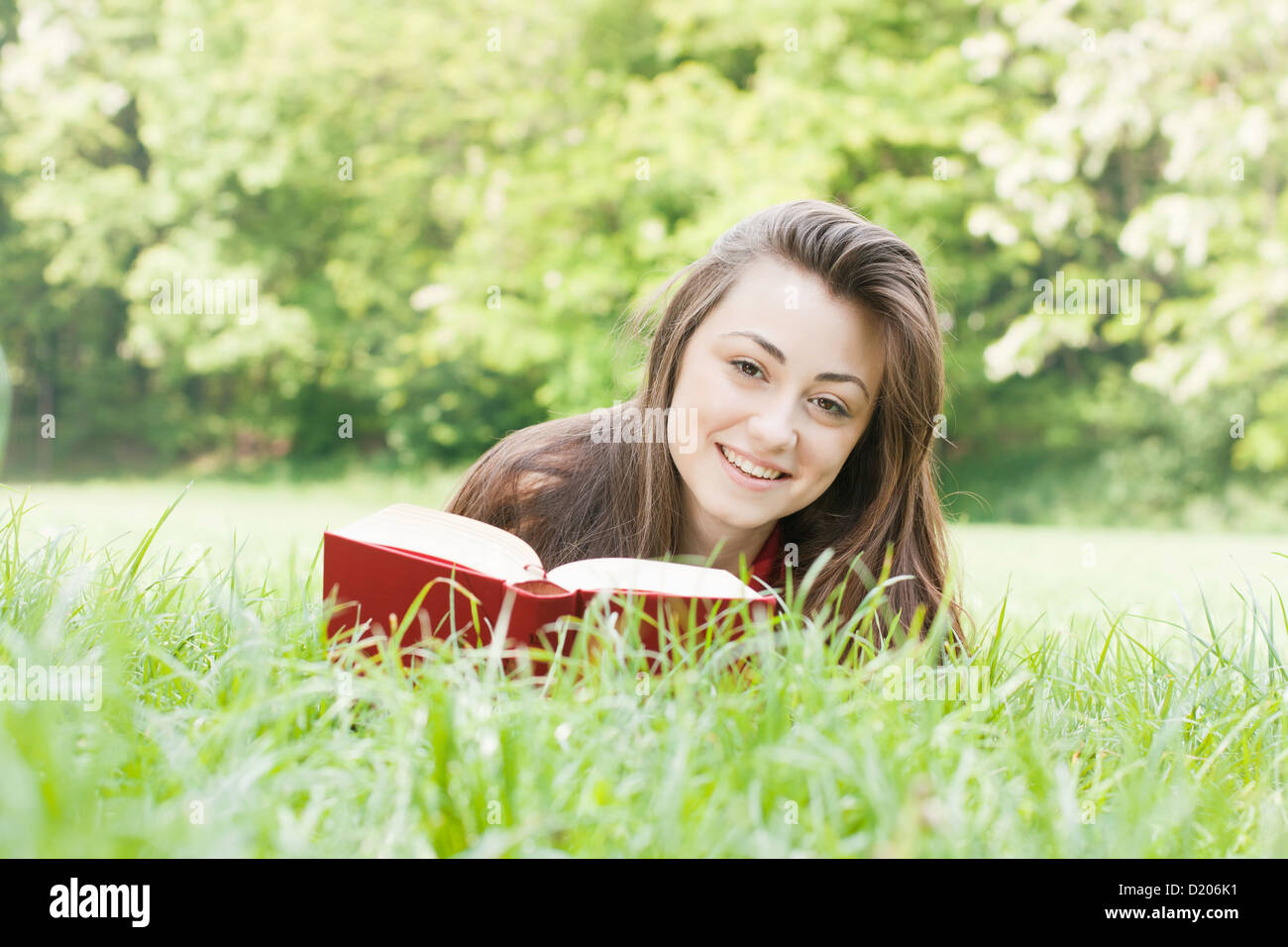 Portrait of happy student relaxed outdoors reading book Stock Photo - Alamy