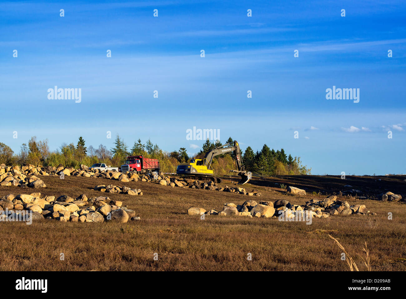 Crane harvests granite boulders from the landscape, Harrington, Maine ...