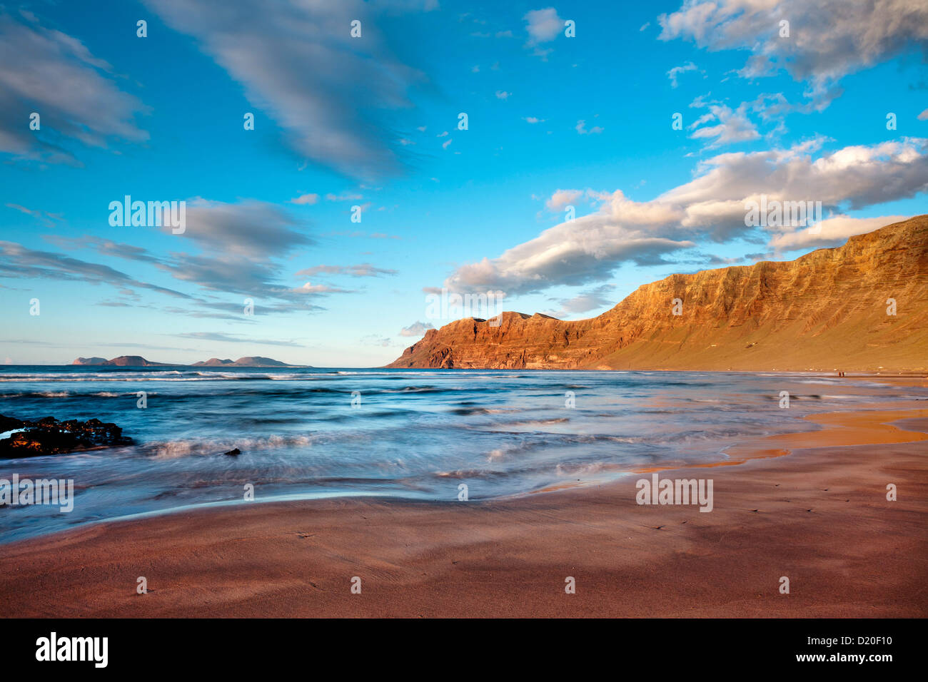 Beach Playa de Famara and mountain range Risco de Famara in the evening ...