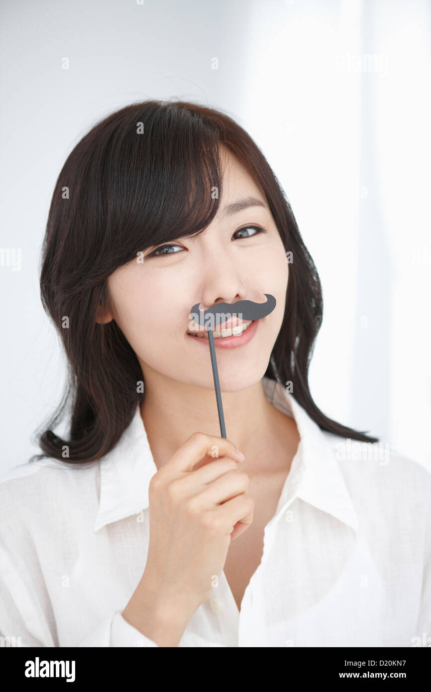 woman wearing white shirt and holding a mustache figure Stock Photo - Alamy