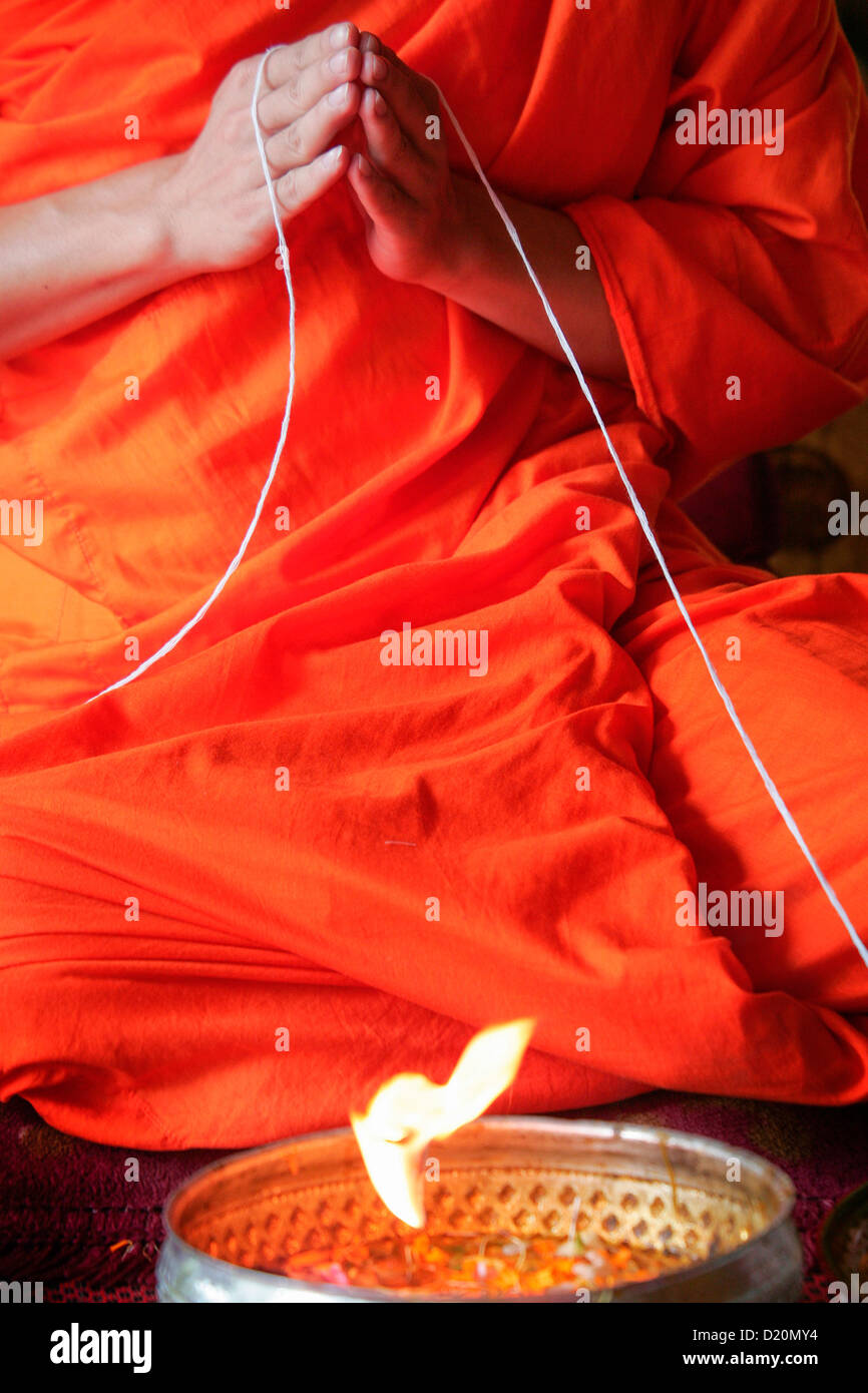 A Buddhist monk performing the Su Khwan or Baci ceremony at Wat Si ...