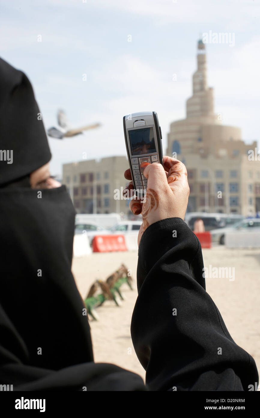 Woman photographing KDF Islamic Center with mobile phone, Doha, Qatar ...