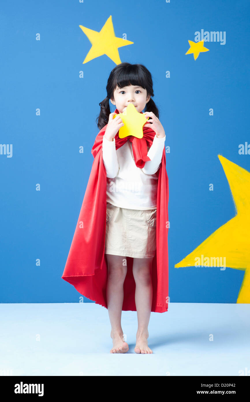a girl holding a star while wearing a red cape in blue background with ...