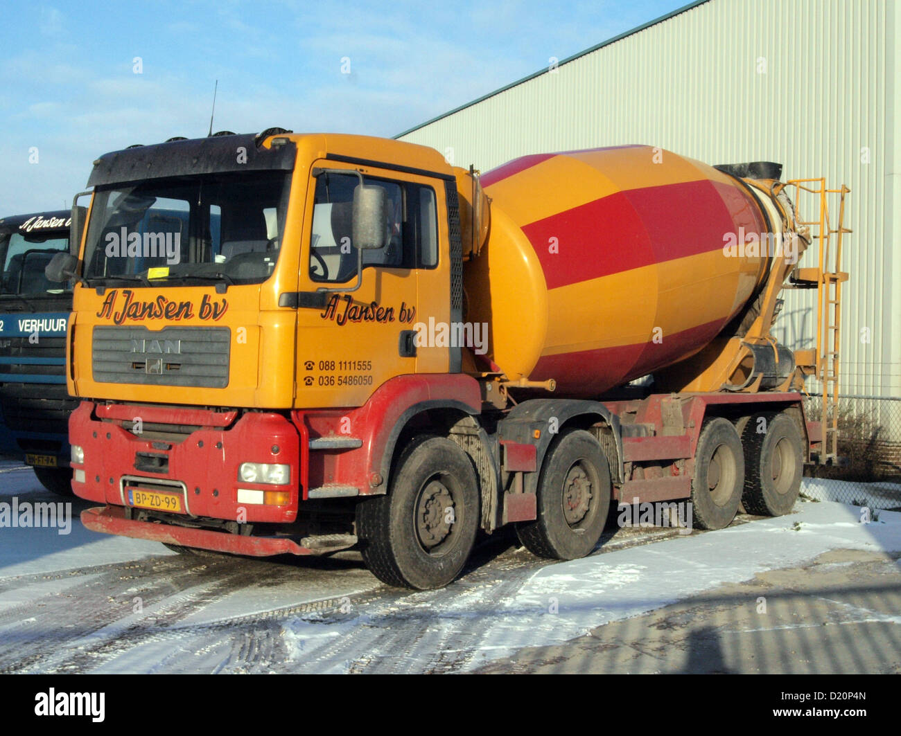 A man operates a cement mixer on a construction site, preparing ...