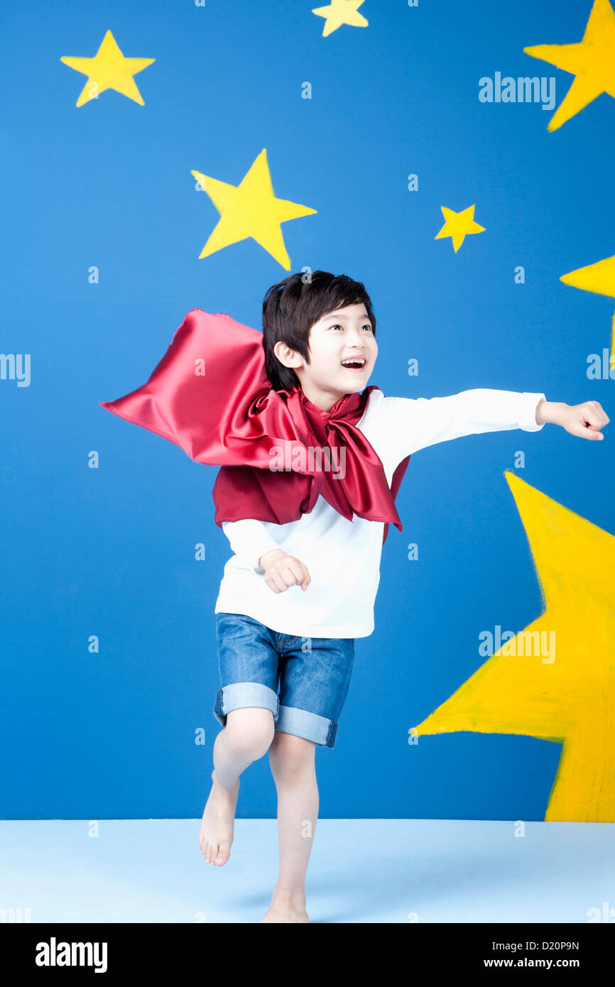 a boy posing like a superman with fluttering red cape Stock Photo - Alamy