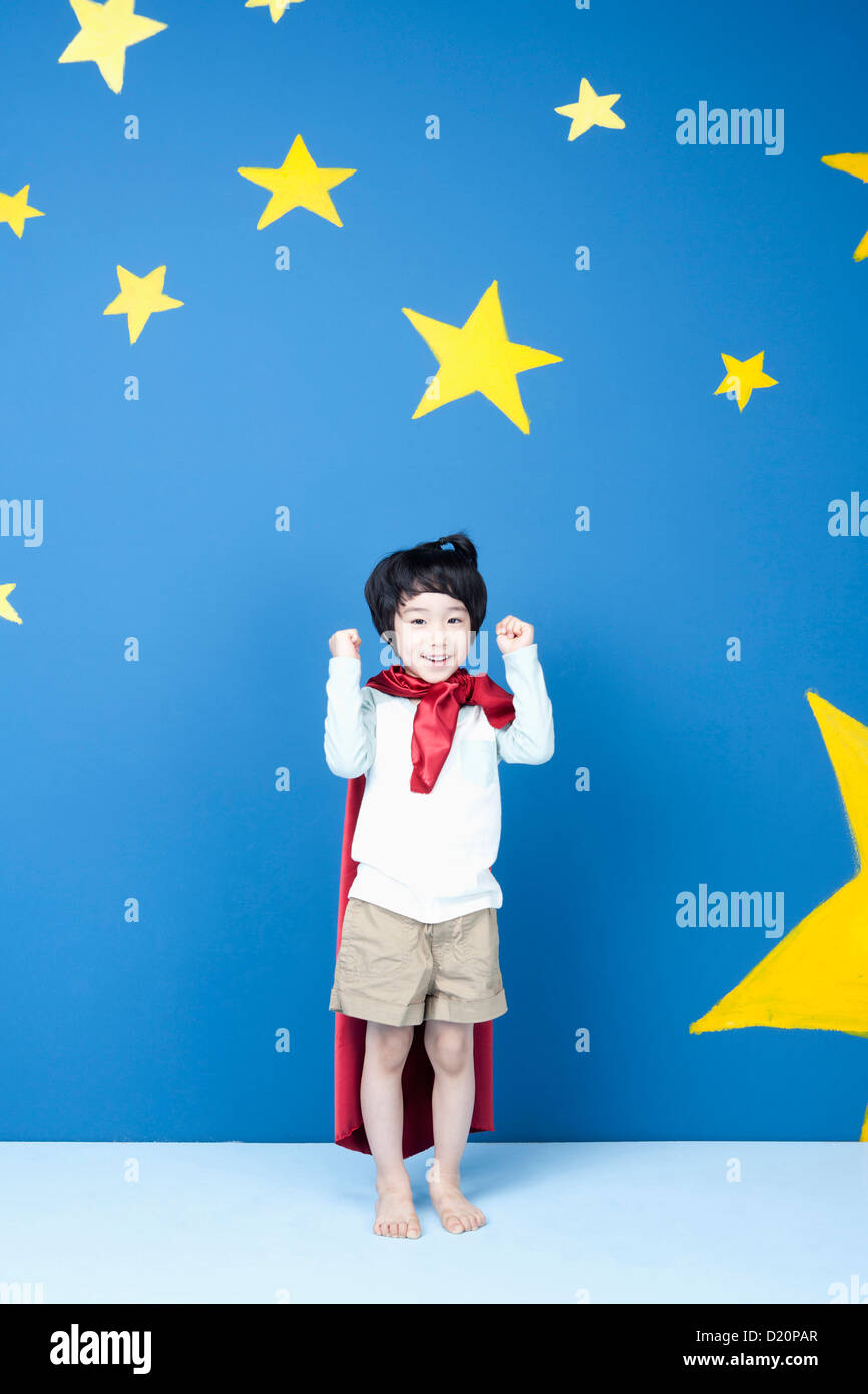 a boy wearing a red cape raising two arms Stock Photo - Alamy