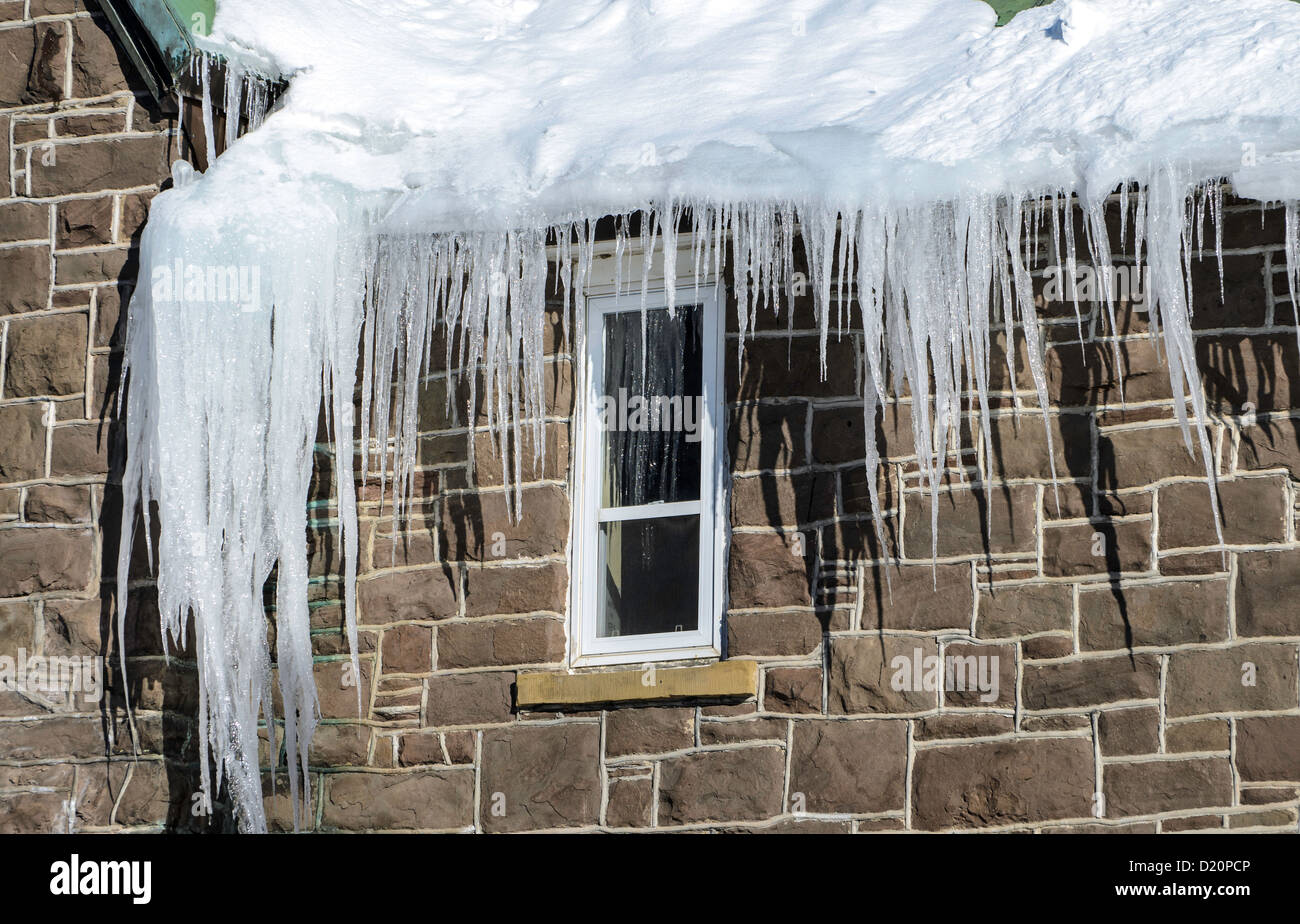 Icecicles hanging off of roof in winter Stock Photo - Alamy