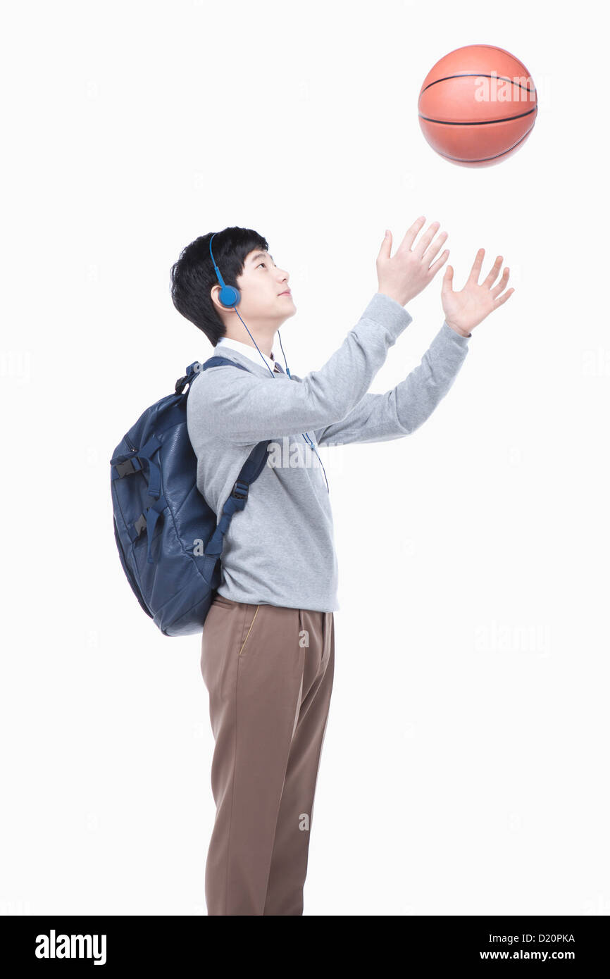 a male student with headphones throwing a basketball in the air Stock ...