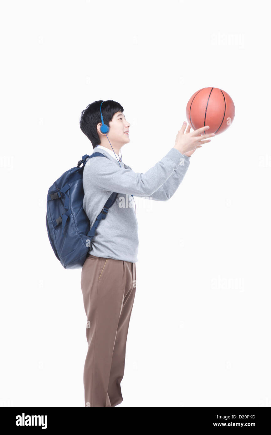 a male student with headphones catching a basketball Stock Photo - Alamy