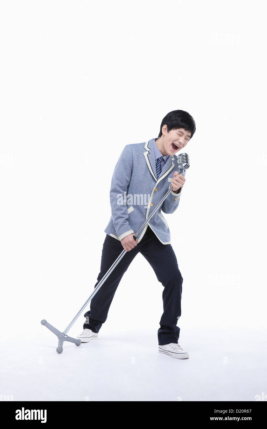 a male student singing while grabbing a microphone stand Stock Photo ...