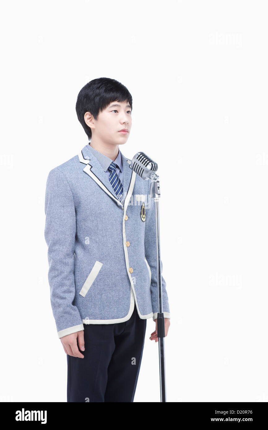 a male student standing behind a microphone stand Stock Photo - Alamy