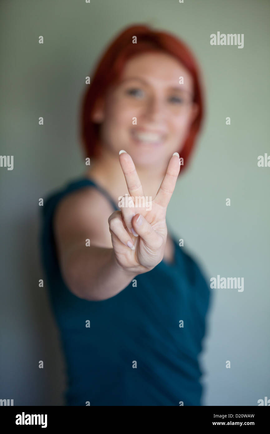 Young woman giving peace sign Stock Photo - Alamy Young woman giving peace sign Stock Photo - Alamy