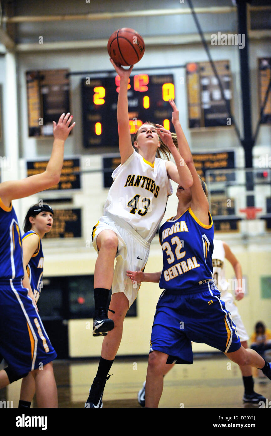 Basketball player splits the defense on a drive to the hoop while ...