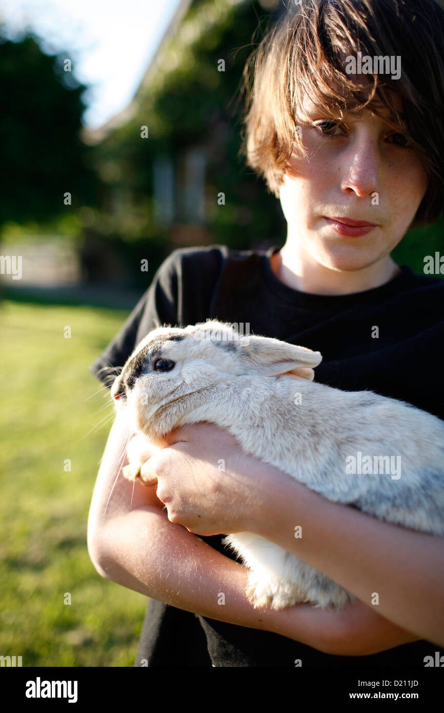 Boy holding rabbit in his arms, Klein Thurow, Roggendorf, Mecklenburg ...