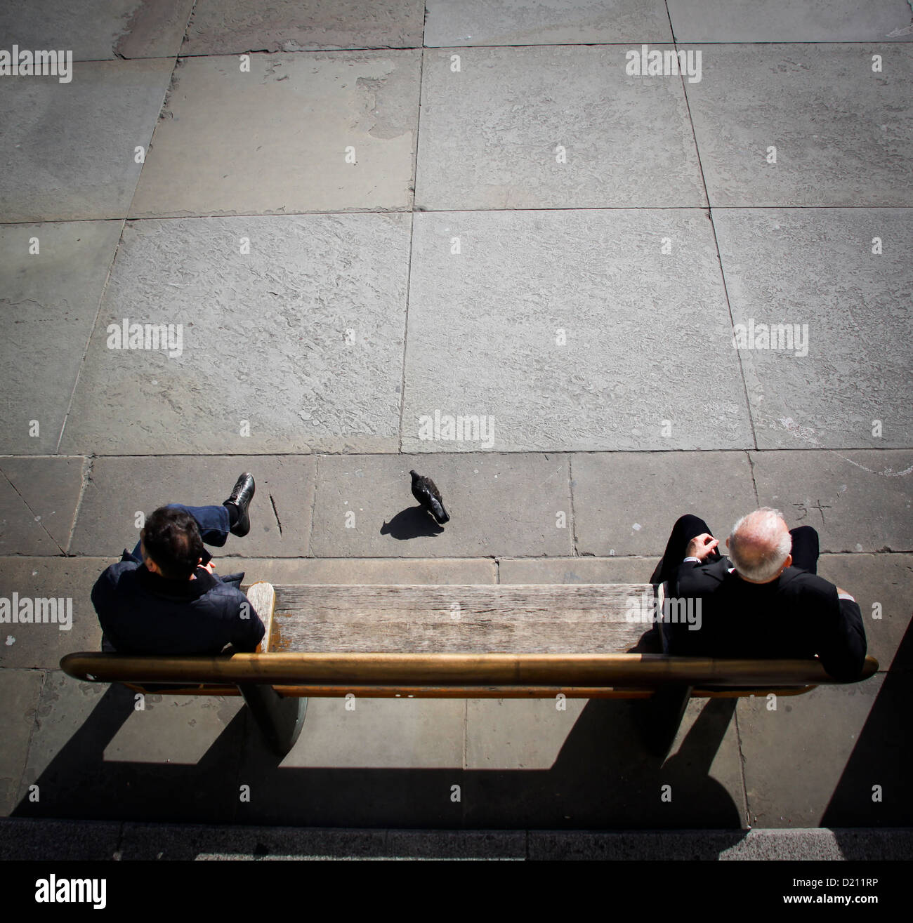 Two men on bench in city square Stock Photo - Alamy