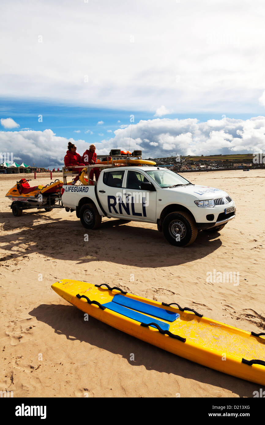 Two RNLI lifeguards ladys women in red coats patrolling Perranporth ...
