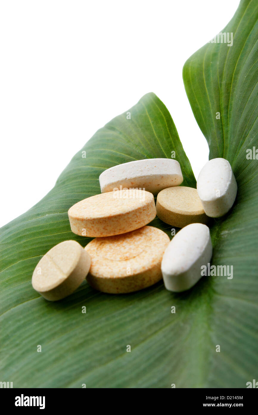 Pills over a leaf in white background Stock Photo - Alamy