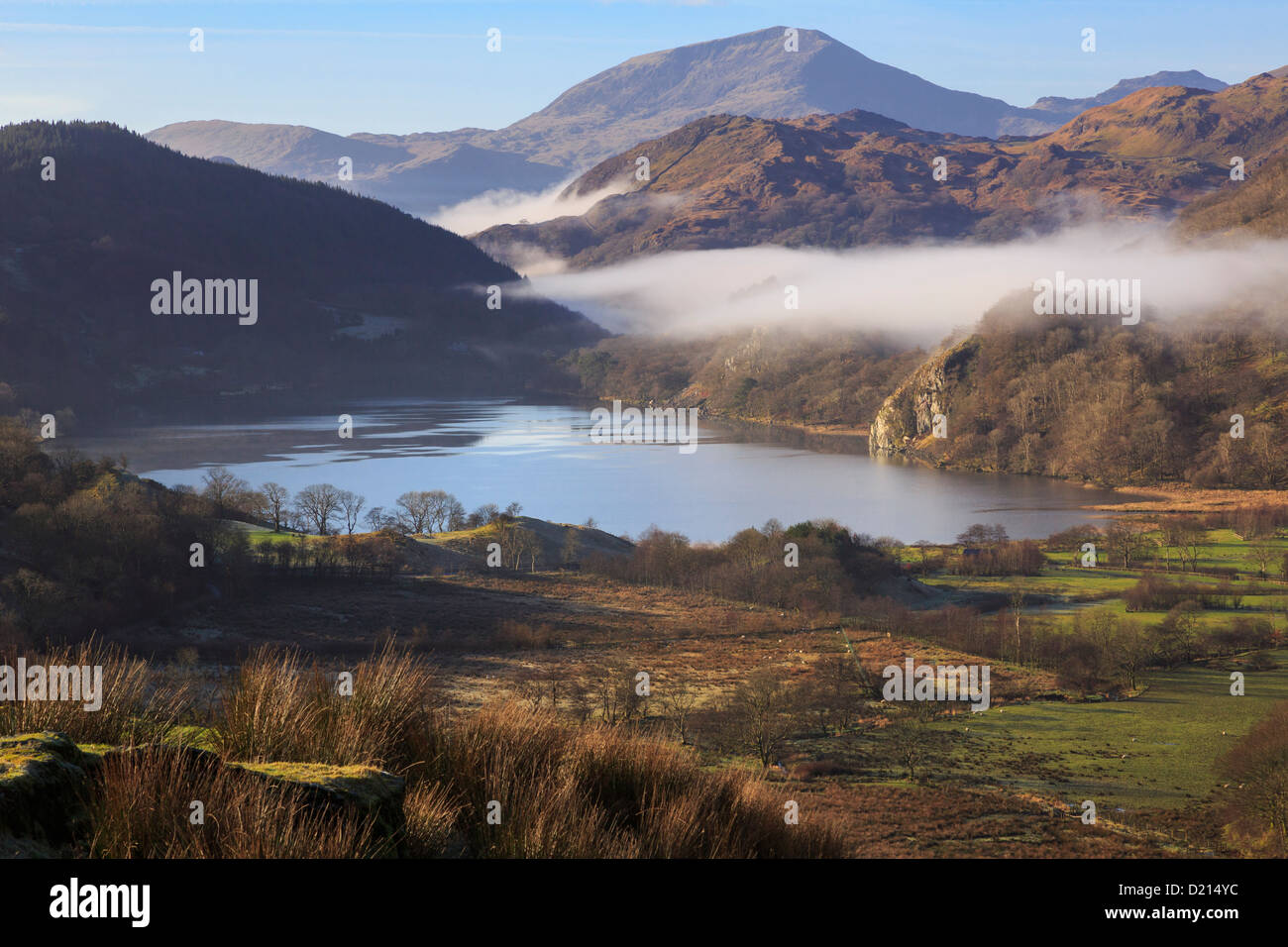 View to Llyn Gwynant lake and Yr Aran mountain with mist in valley in ...