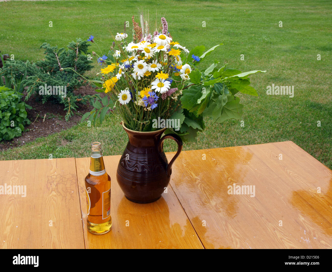 Midsummer day bouquet from different wild country flowers and bottle ...