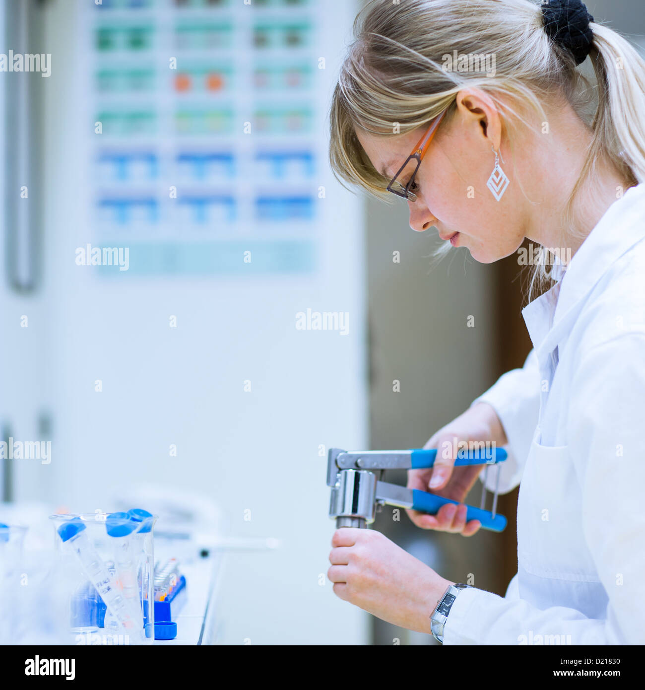 female researcher carrying out research experiments in a chemistry lab ...