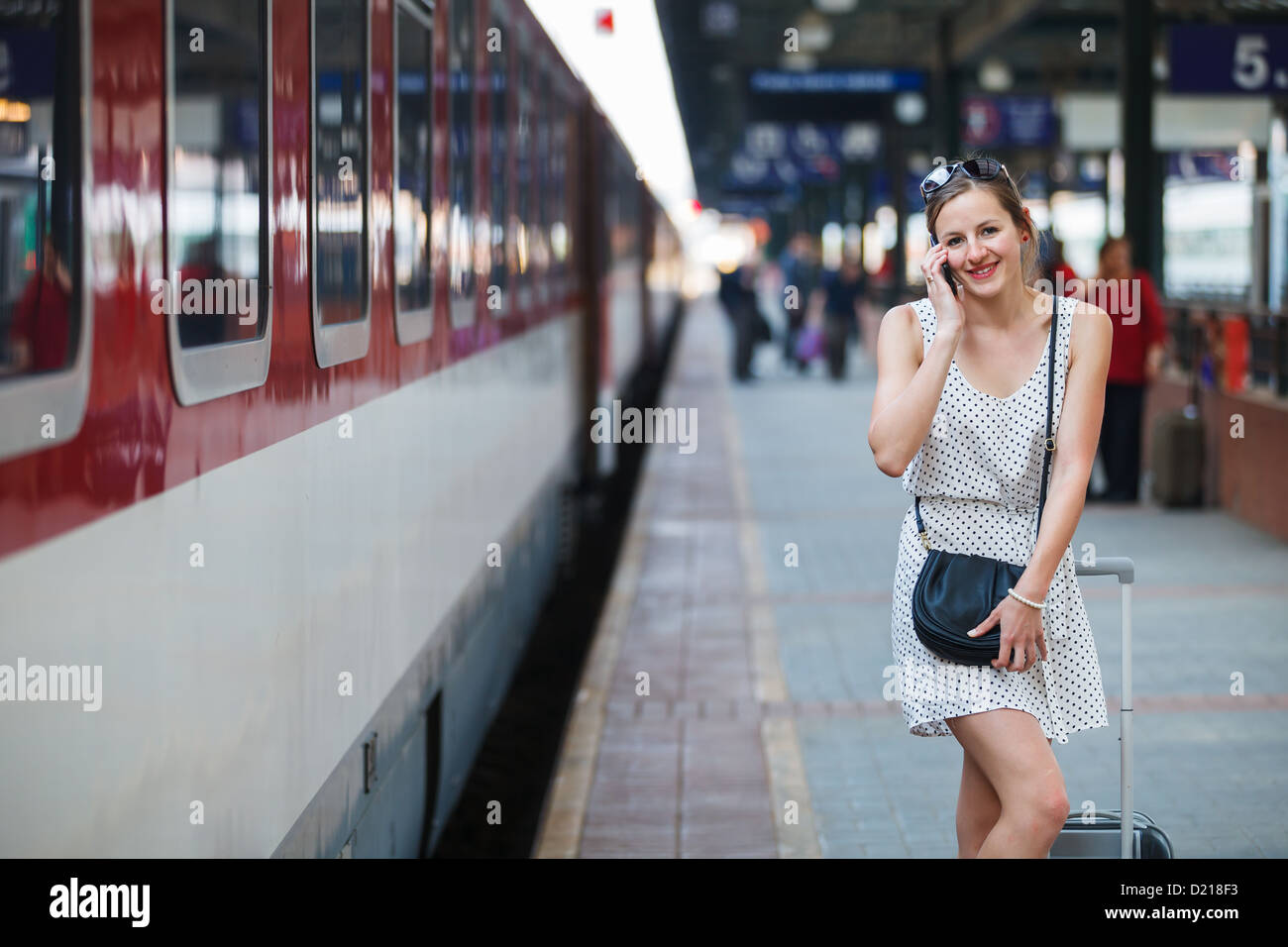 Pretty young woman at a train station Stock Photo - Alamy
