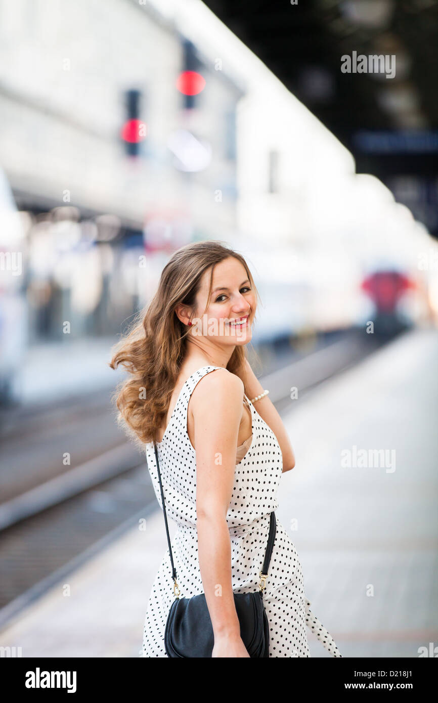 Pretty young woman at a train station Stock Photo - Alamy