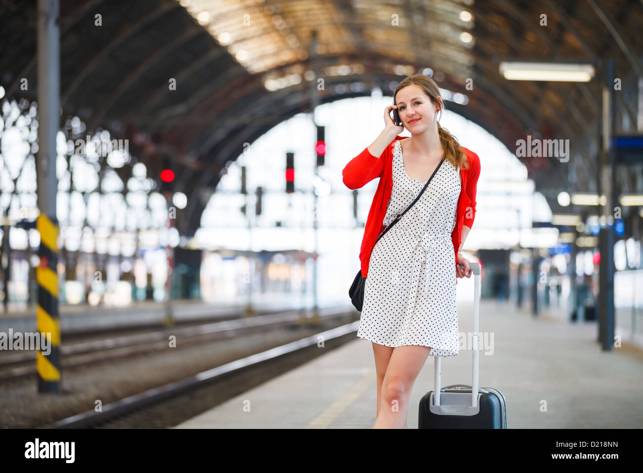 Pretty young woman at a train station Stock Photo - Alamy