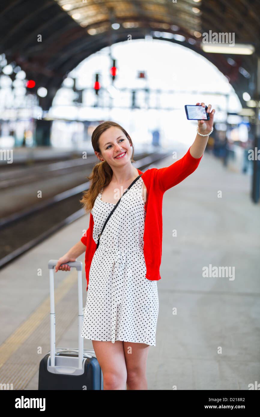 Pretty young woman at a train station Stock Photo - Alamy