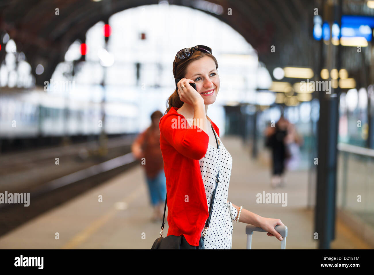 Pretty young woman at a train station Stock Photo - Alamy