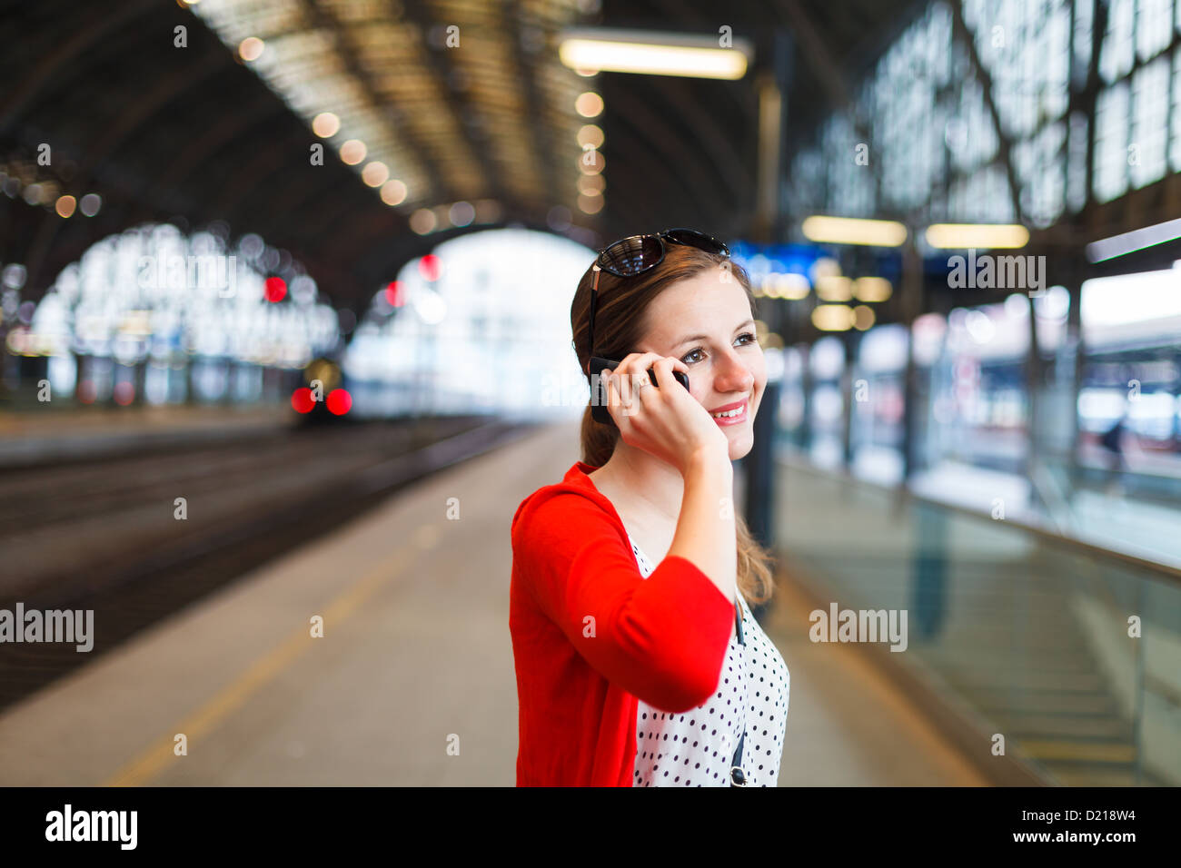 Pretty young woman at a train station Stock Photo - Alamy