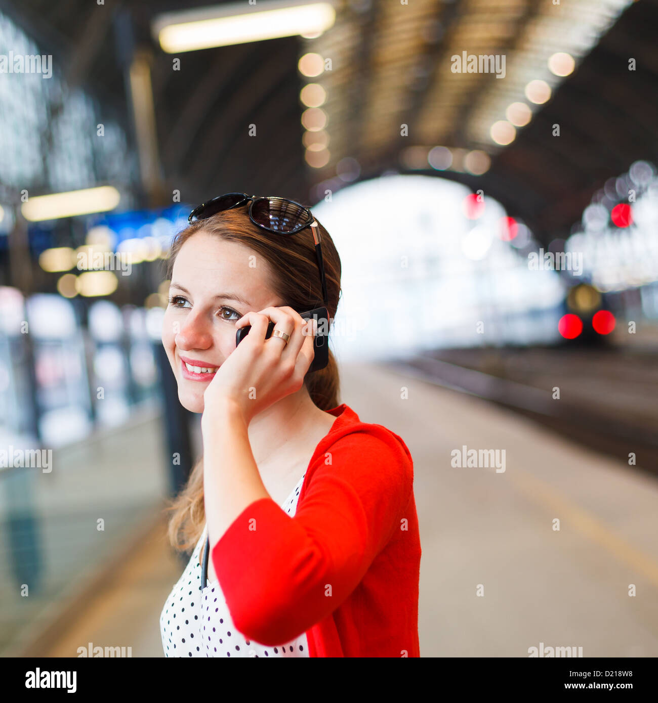 Pretty young woman at a train station Stock Photo - Alamy